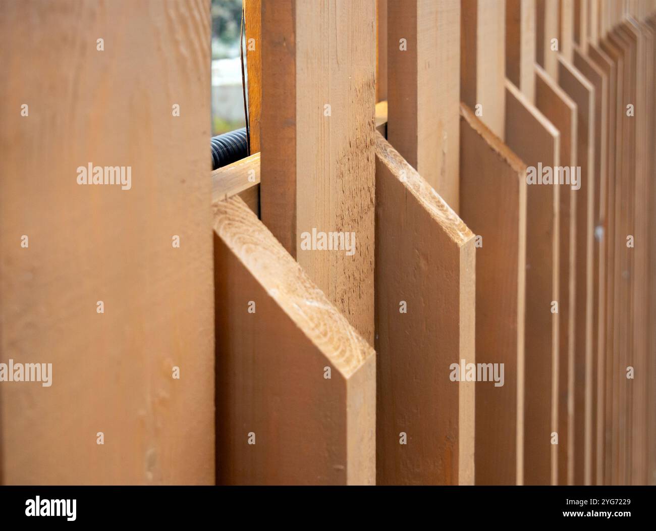Fragment of a wooden fence with protruding slats Stock Photo - Alamy