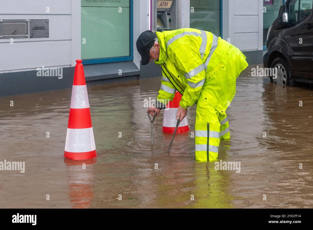 Cork County Council Worker struggles to clear a drain during floods in ...