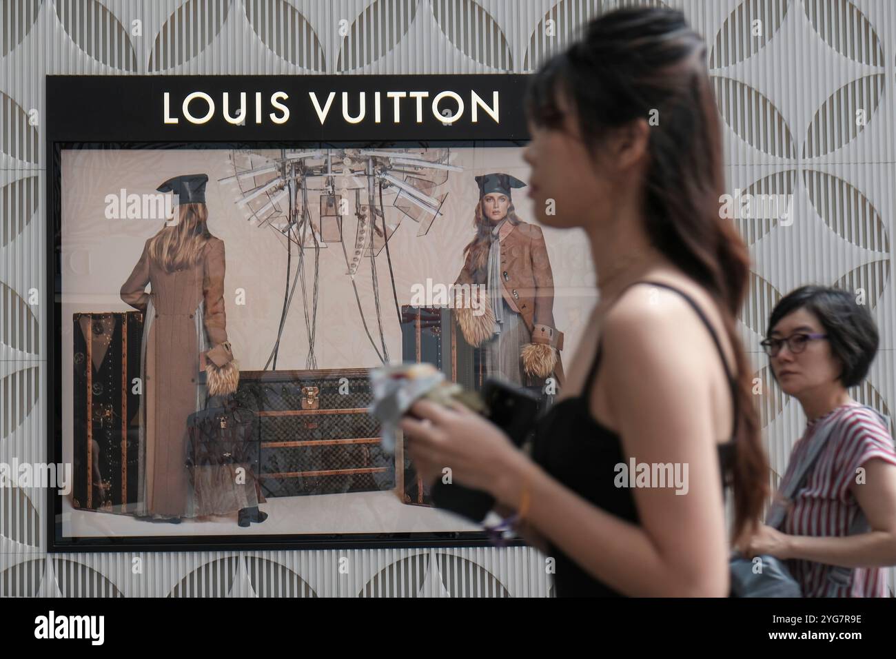 People seen passing by Louis Vuitton advertisement Stock Photo - Alamy