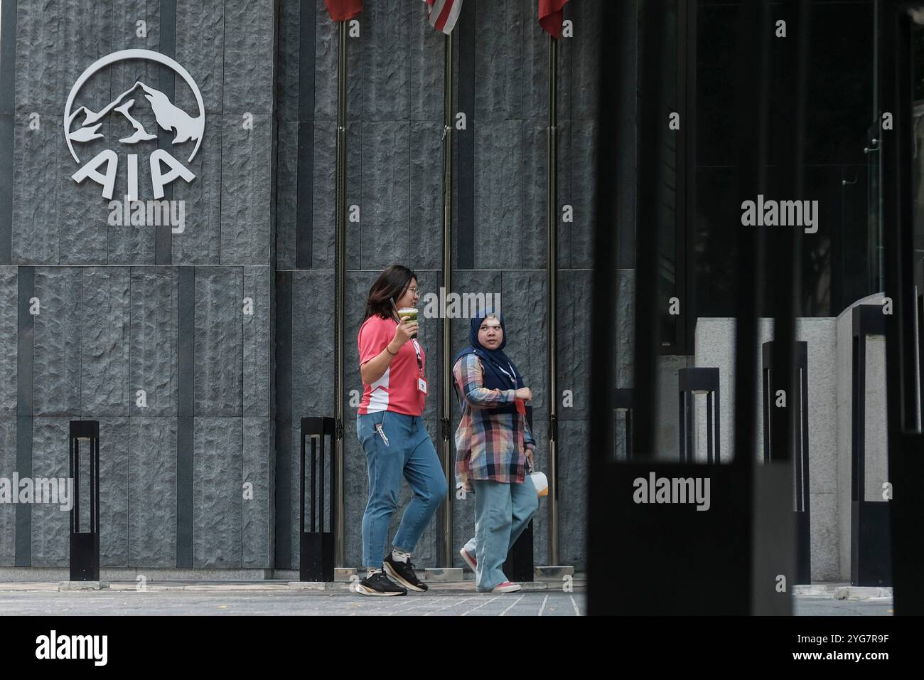 People seen passing by AIA insurance logo Stock Photo - Alamy