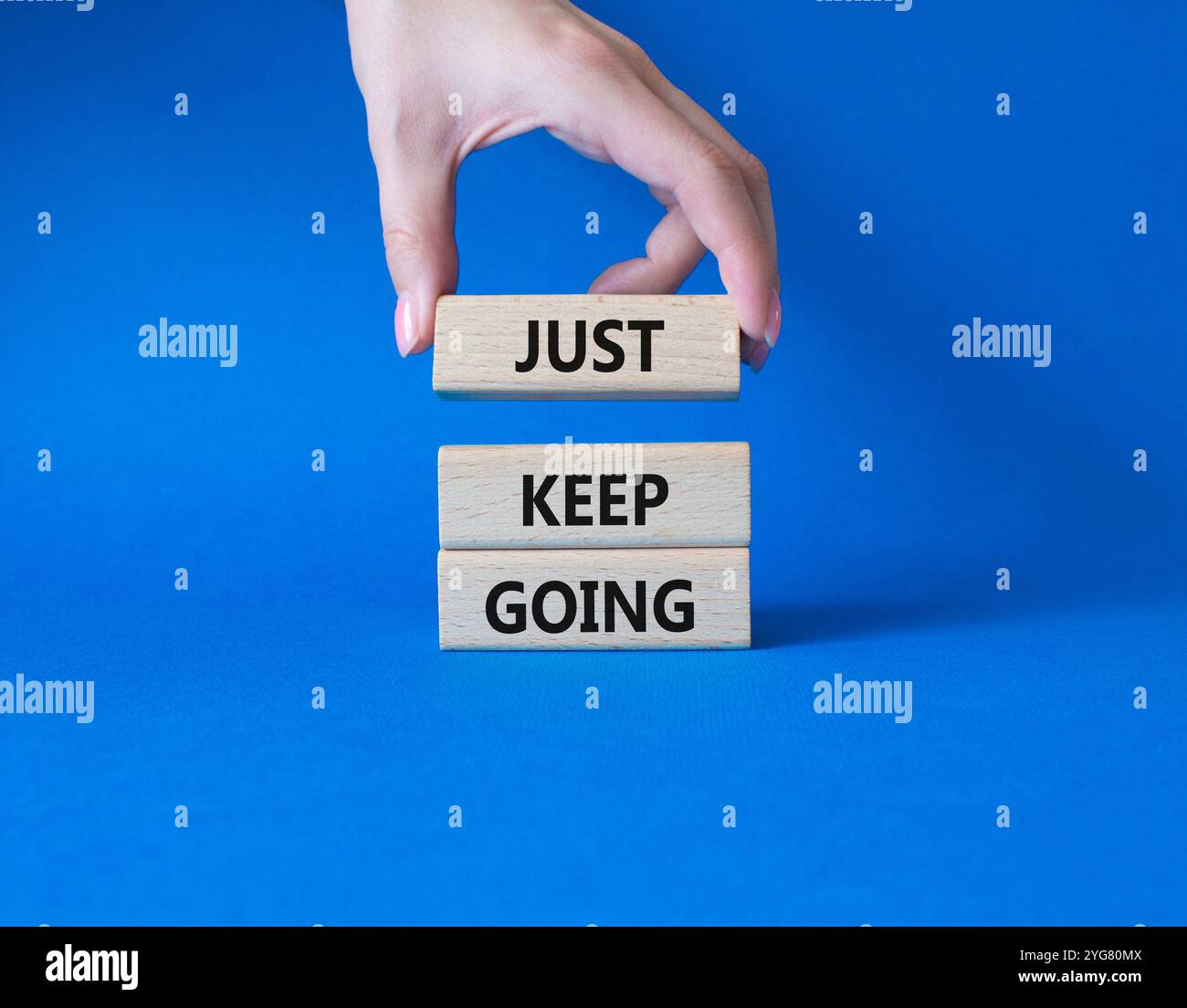 Just keep going symbol. Concept words Just keep going on wooden blocks. Beautiful blue ...