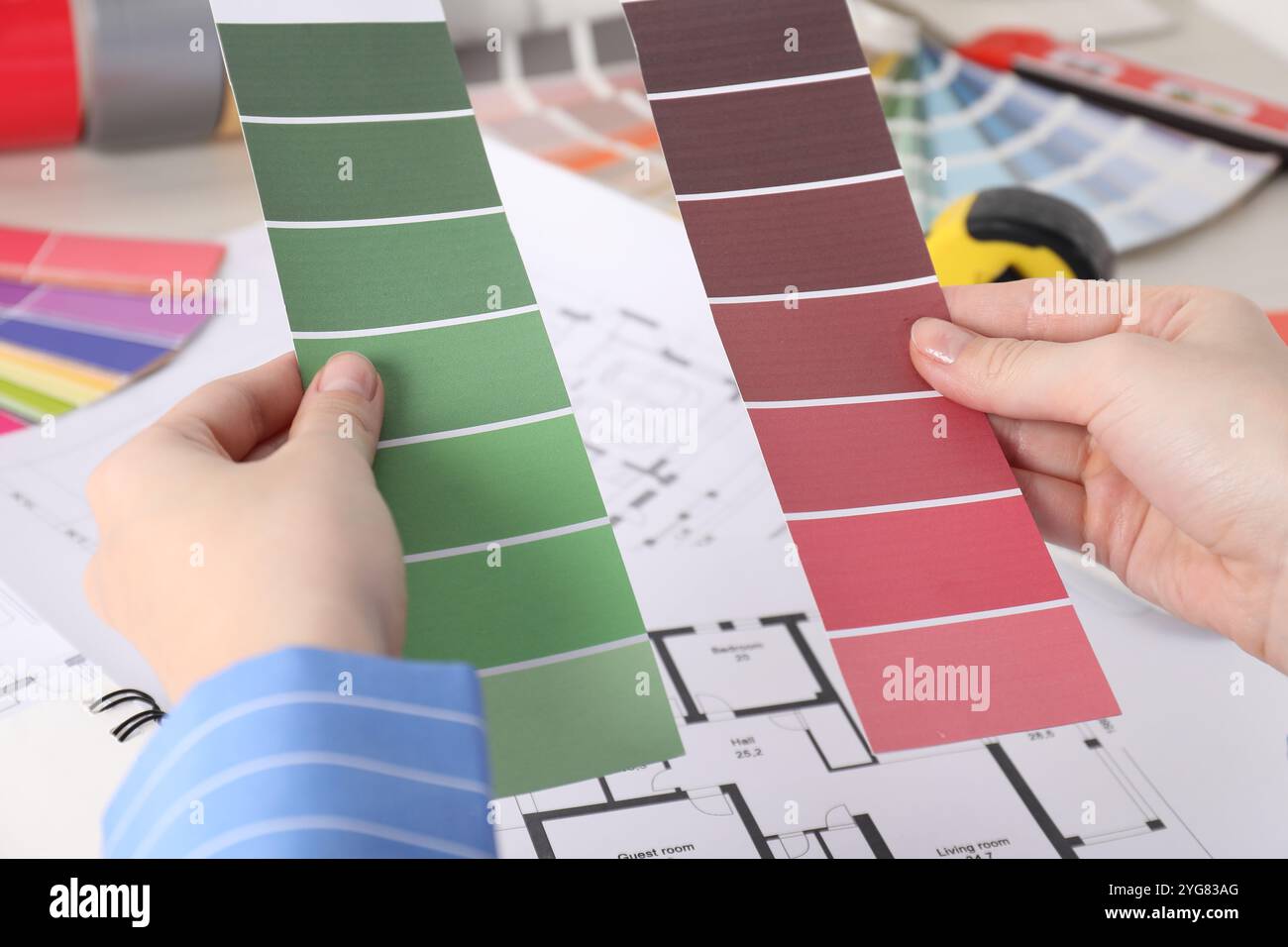 Designer with color selection chart working on house project at table ...