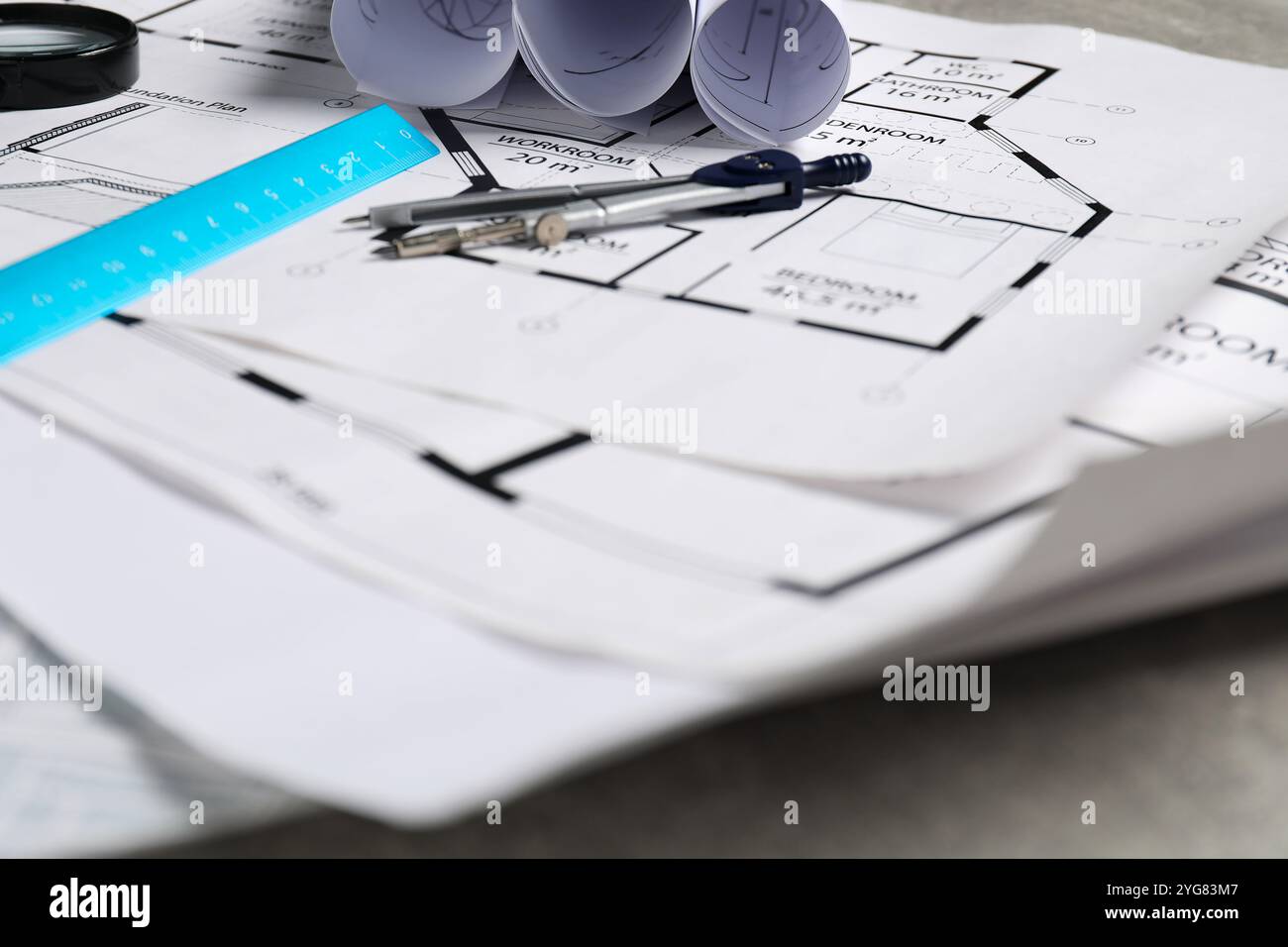Different architectural drawings, divider and ruler on grey table ...