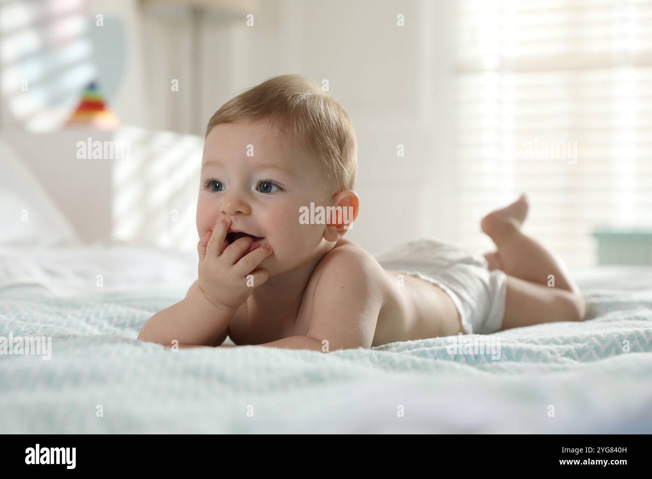 Cute little baby in diaper on bed at home Stock Photo - Alamy
