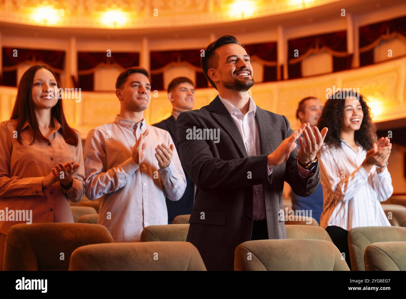 Group of exited people applauding in theatre Stock Photo - Alamy