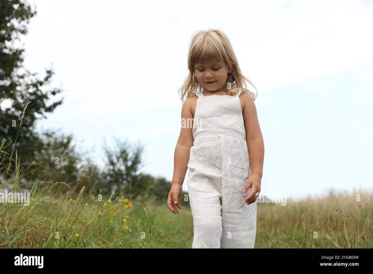Cute little girl walking at meadow. Child enjoying beautiful nature ...