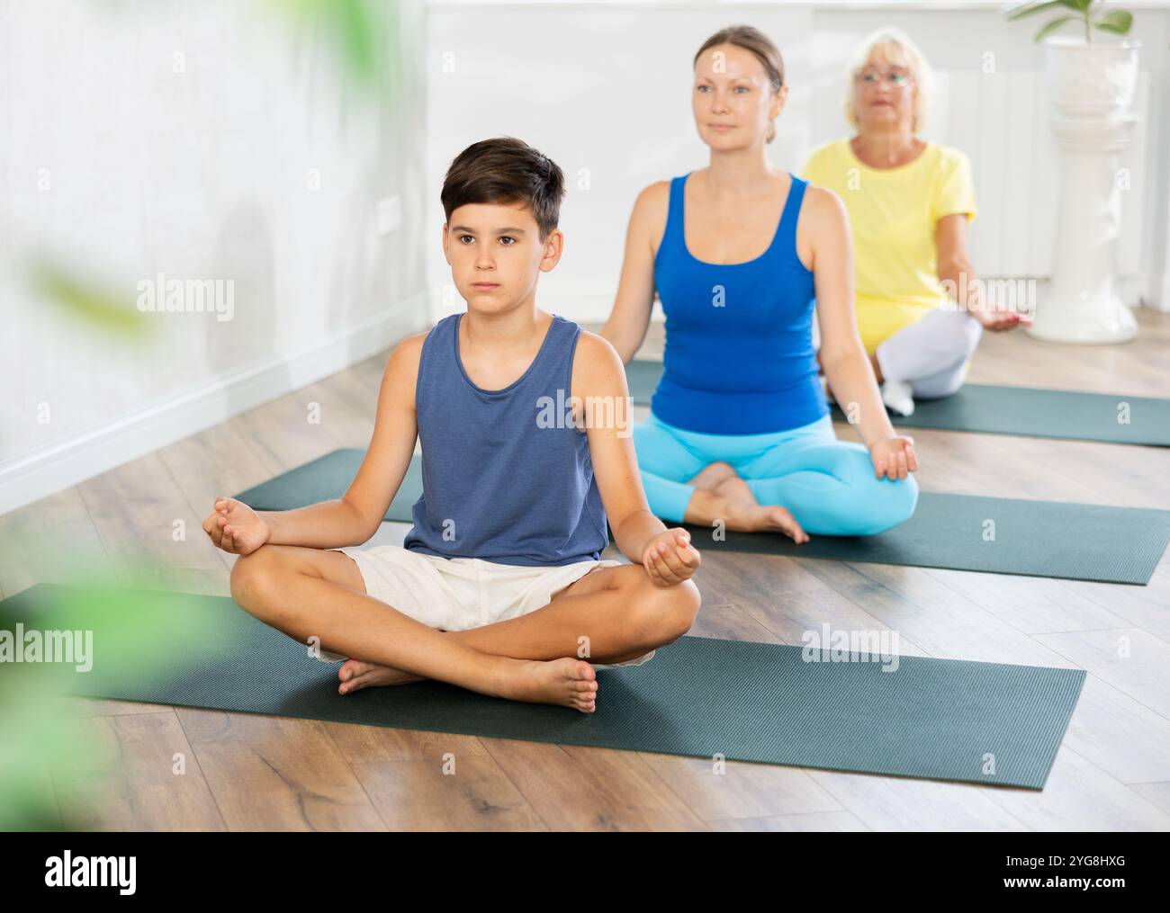 Family three generations do half lotus position Sidhasana with hands ...