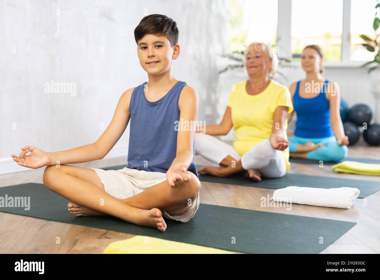 Family three generations do half lotus position Sidhasana with hands ...