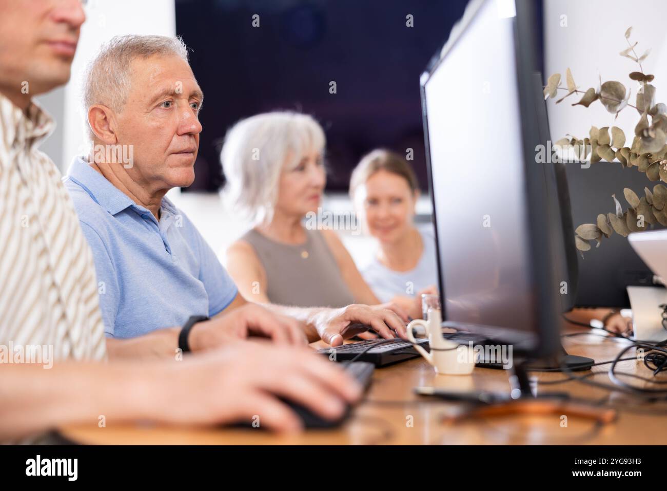Old man learning computer programs in training room Stock Photo - Alamy