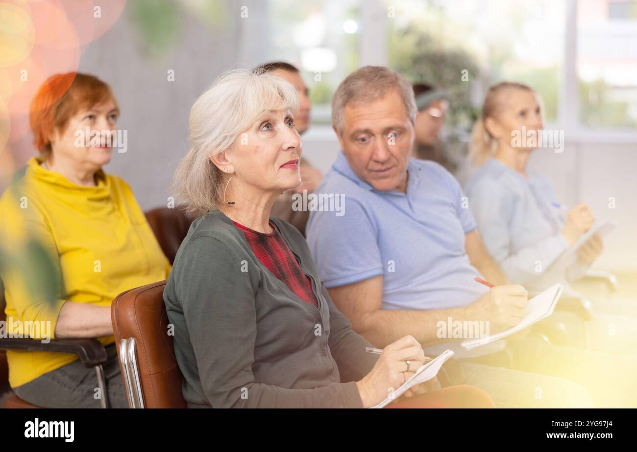 Group of older students sitting and listening at lesson Stock Photo - Alamy