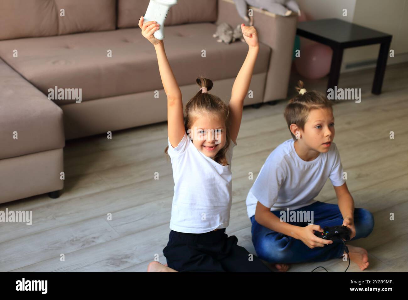 A lively scene of a boy and girl enthusiastically playing video games ...