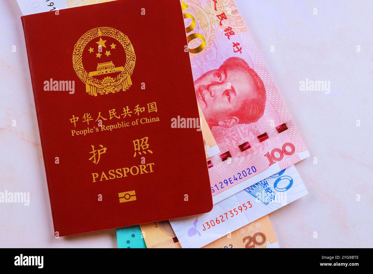 Chinese passport with yuan cash banknotes of varying denominations is ...