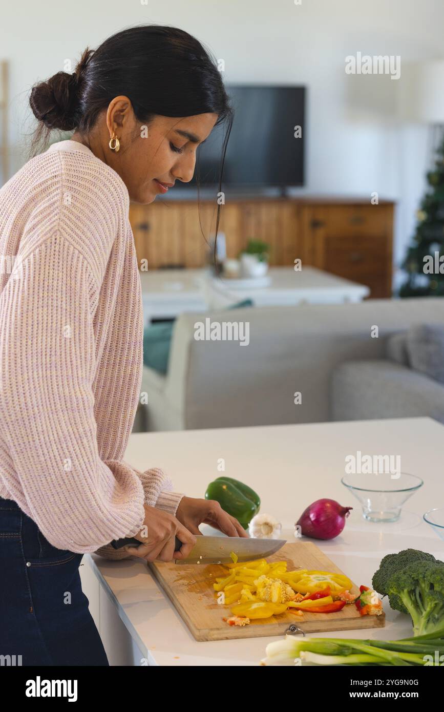 Christmas time, Asian woman chopping vegetables in kitchen, preparing ...