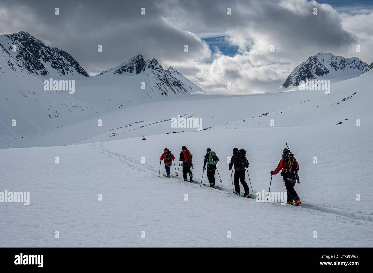 Svalbard, Norway. Group of backcountry skiers climbing toward some ...