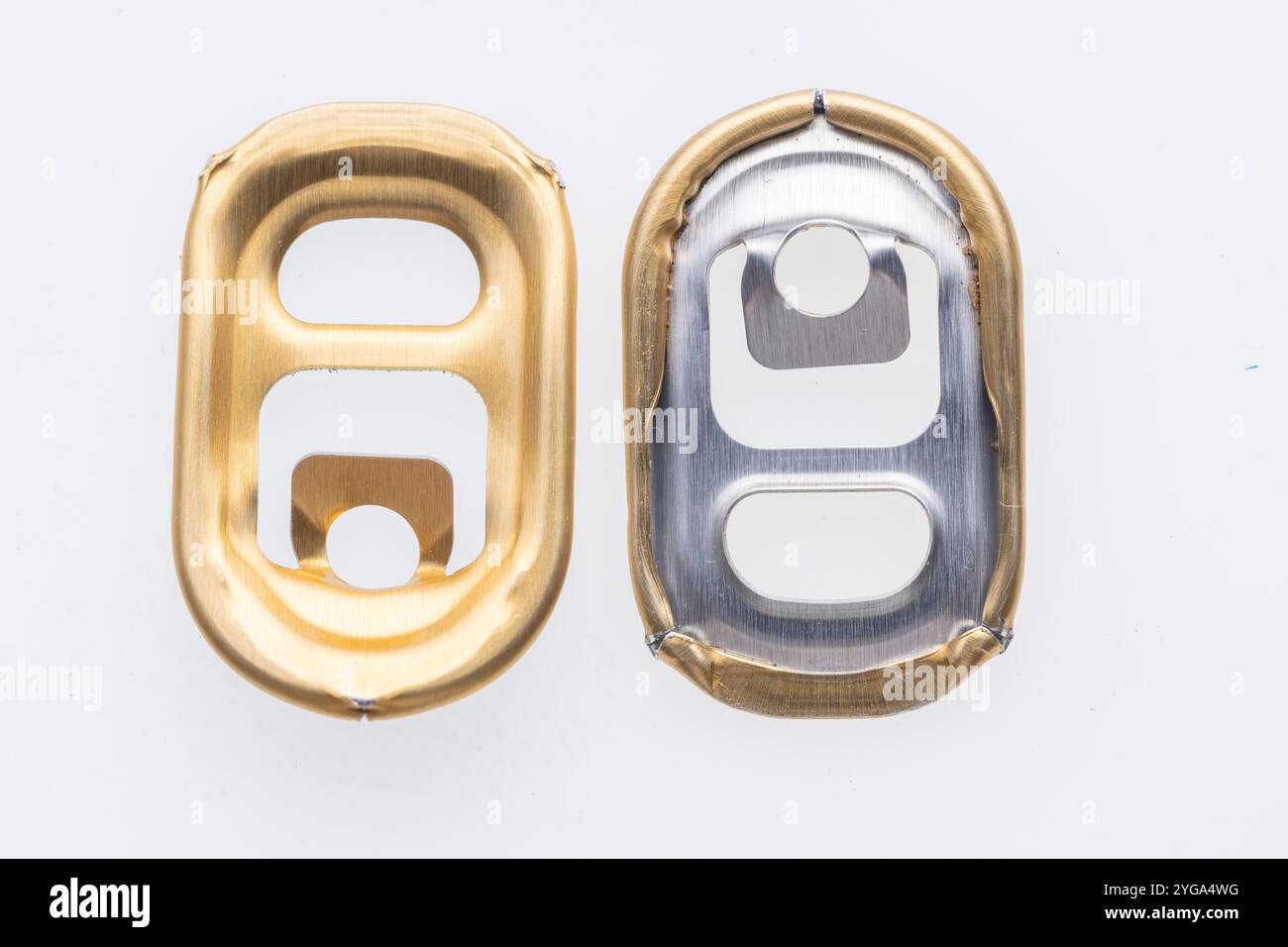 Two metal can tops are shown against a white background. One is gold ...