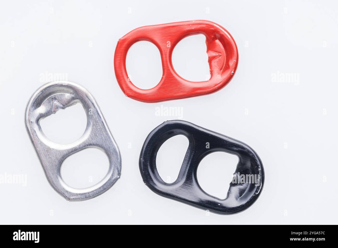 Three can pull tabs, one red, one silver, and one black, are arranged ...