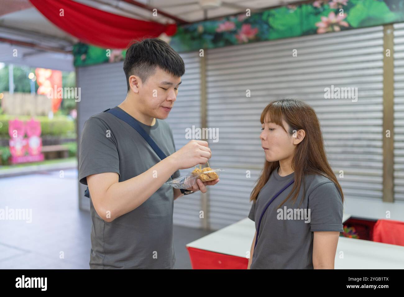 Chinese Malaysian couple in their 30s buying and eating kinako mochi ...