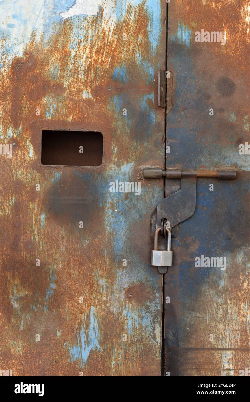old rusty iron door with a padlock Stock Photo - Alamy