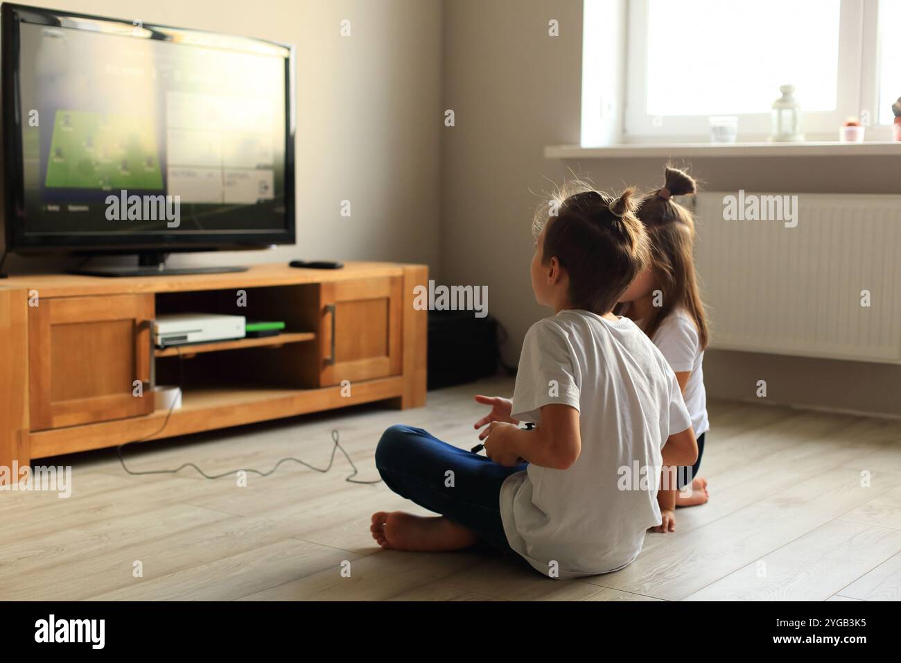 A lively scene of a boy and girl enthusiastically playing video games ...