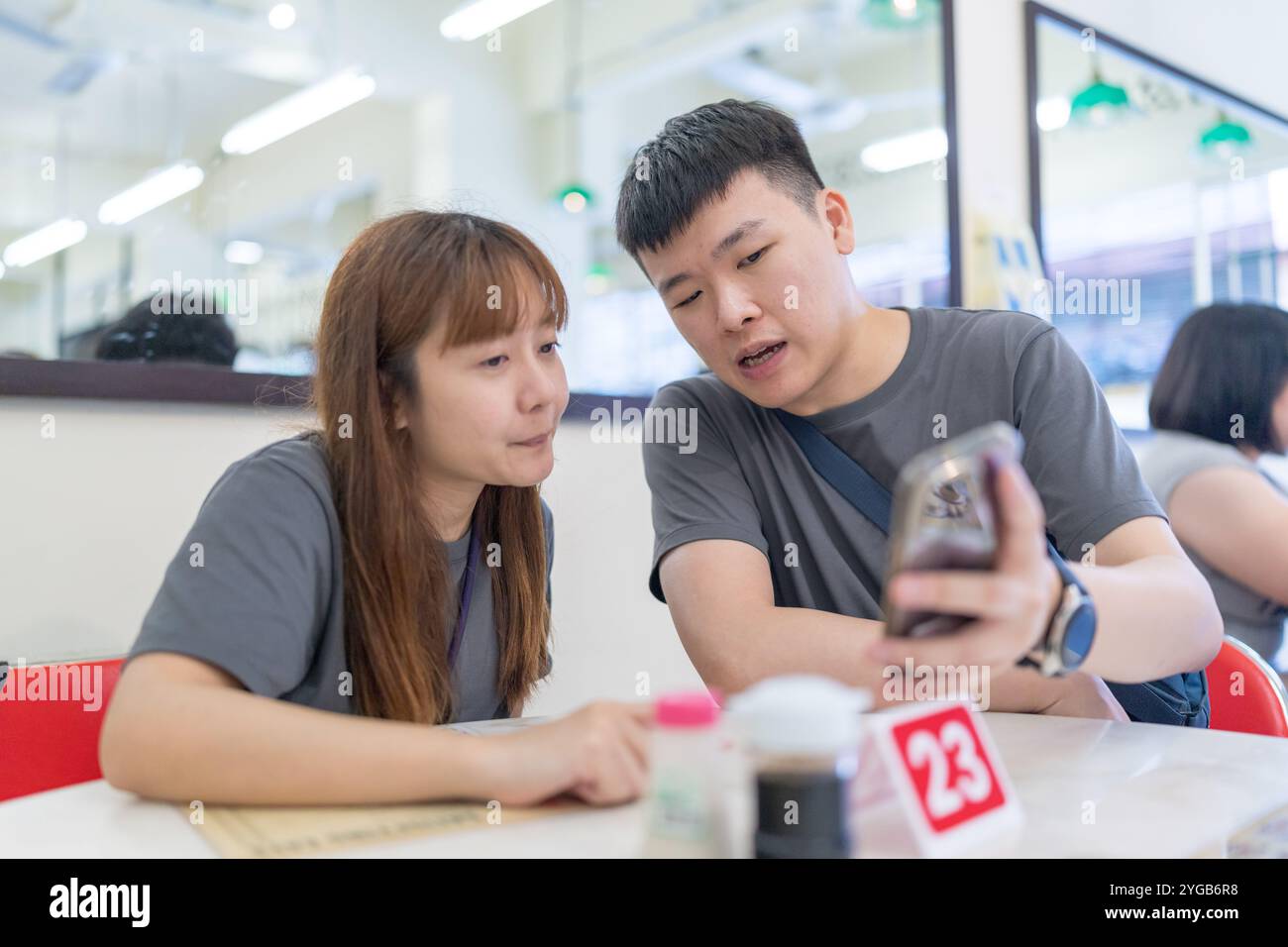 Chinese Malaysian couple in their 30s chatting at a famous local Chinese restaurant in Kuala ...