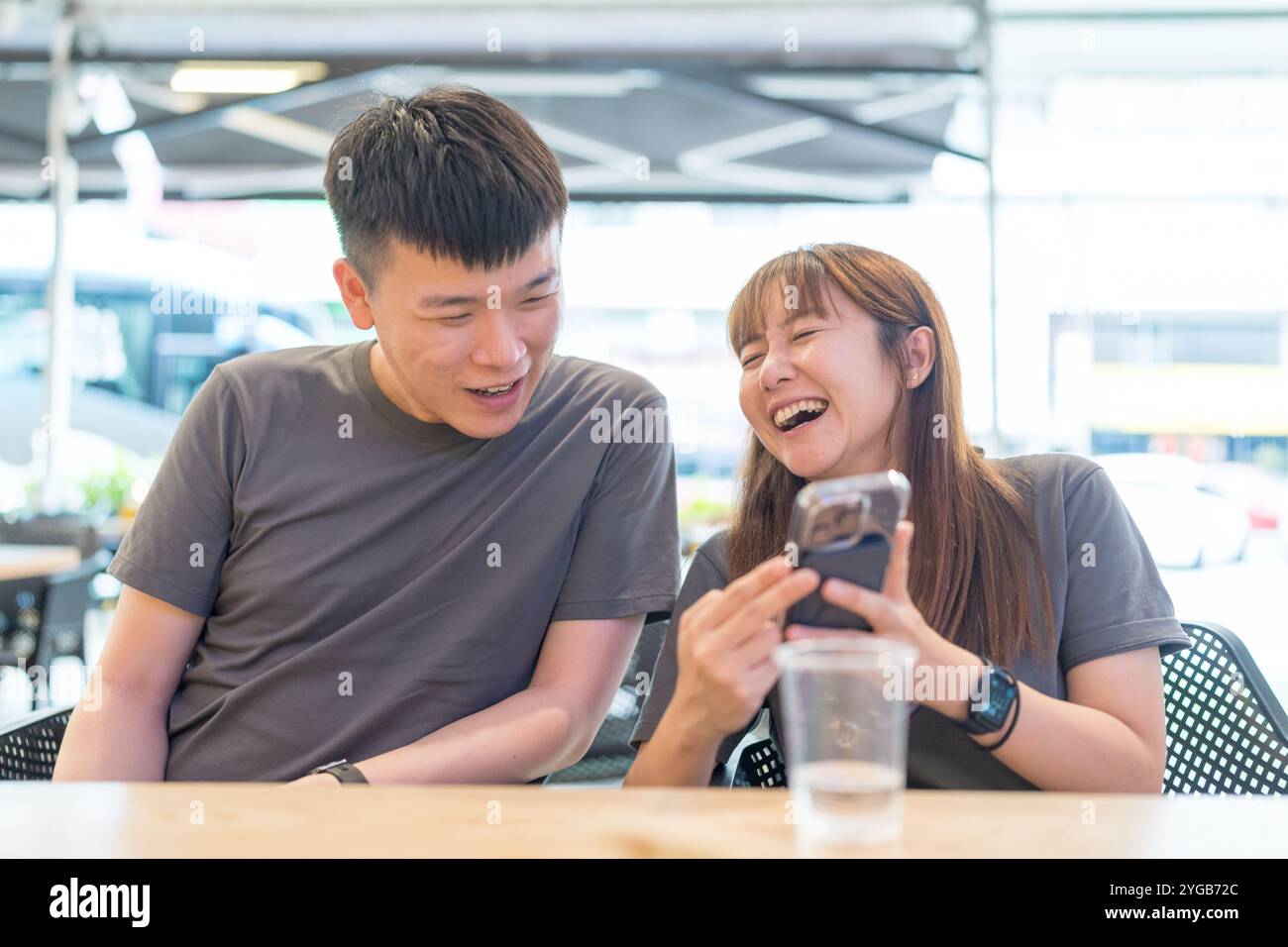 June 2024. A Chinese-Malaysian couple in their 30s chat while eating ...