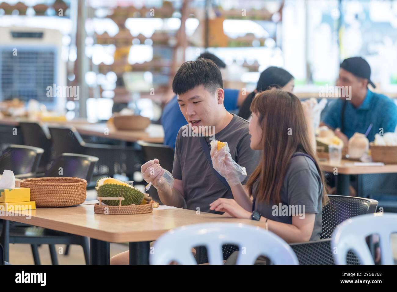 June 2024. A Chinese-Malaysian couple in their 30s chat while eating durian at a famous ...