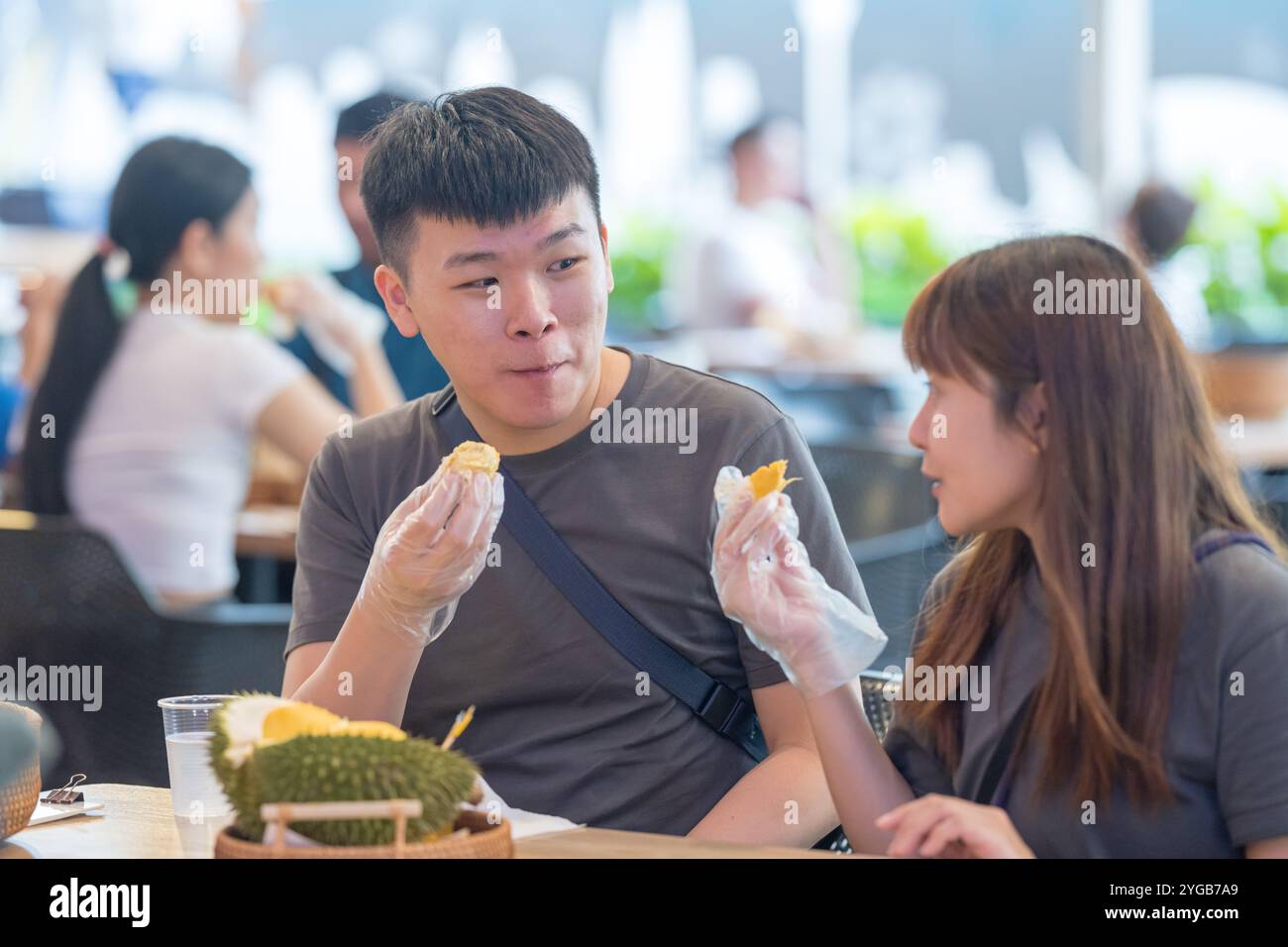 June 2024. A Chinese-Malaysian couple in their 30s chat while eating durian at a famous ...