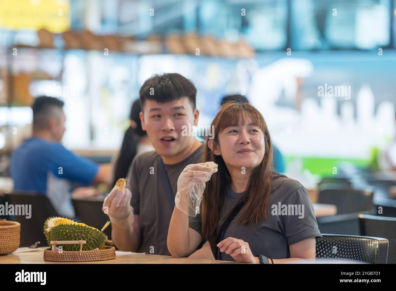 June 2024. A Chinese-Malaysian couple in their 30s chat while eating durian at a famous ...