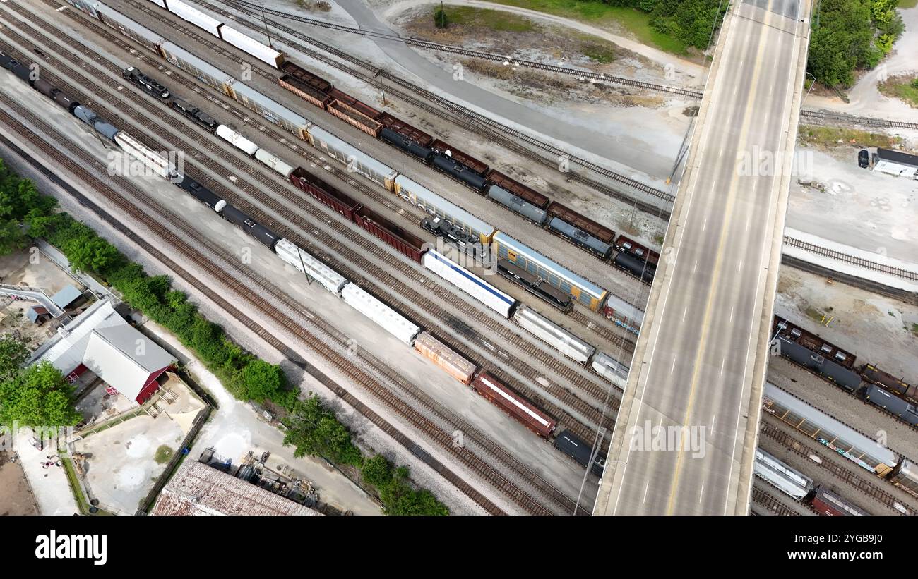 An overhead drone shot captures the railroad tracks as a train passes ...