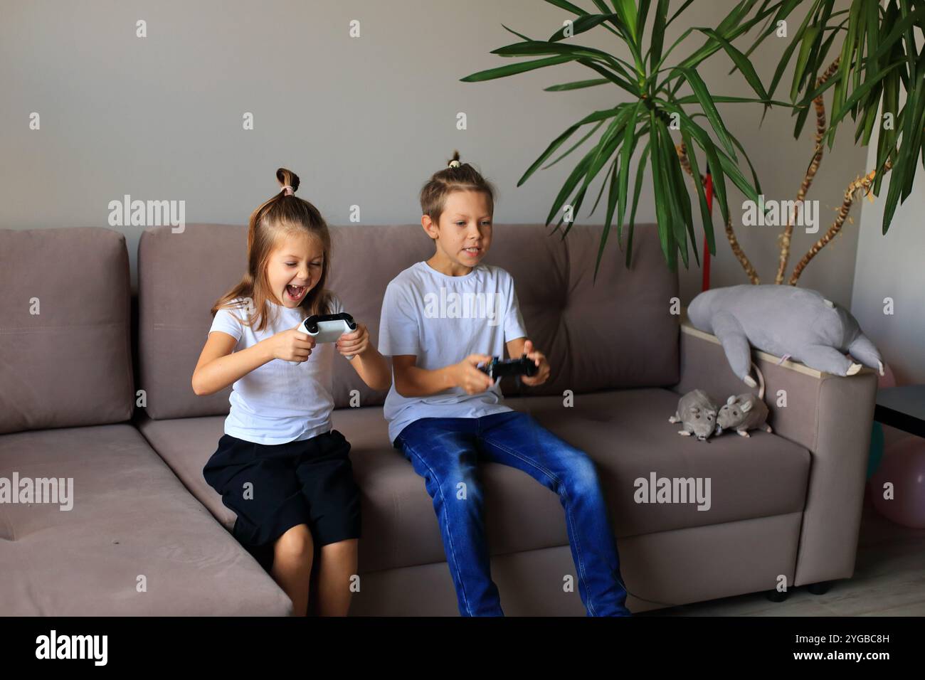 A lively scene of a boy and girl enthusiastically playing video games ...
