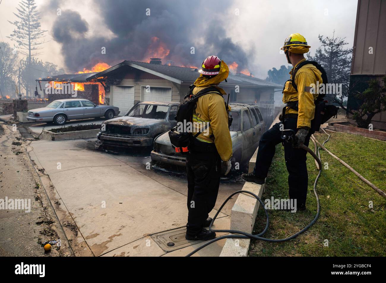 LAFD firefighters look upon a burning house overtaken by the Mountain ...