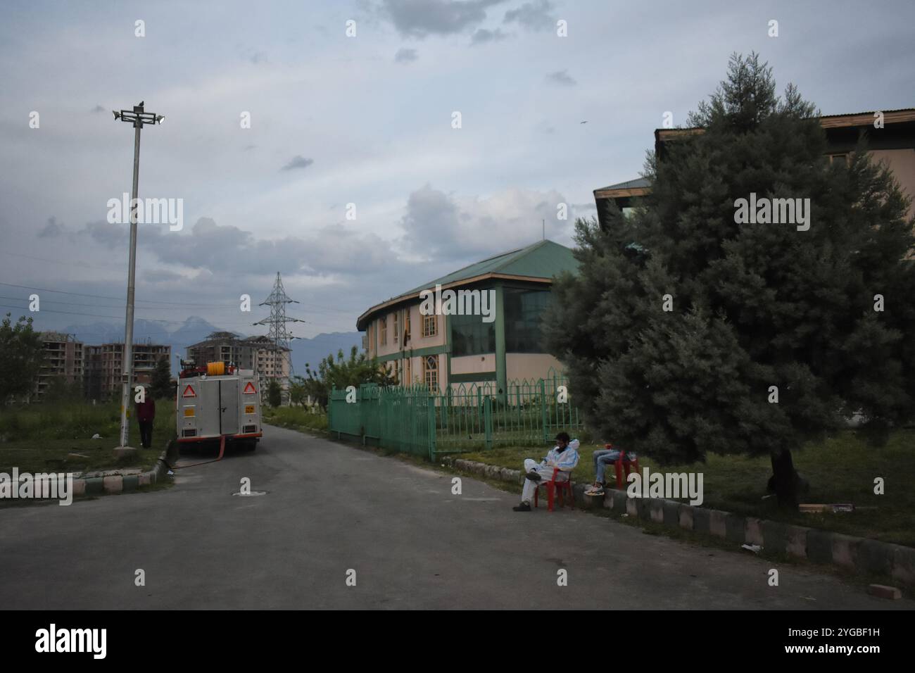 Volunteers sit outside a temporary hospital in Srinagar, Indian ...