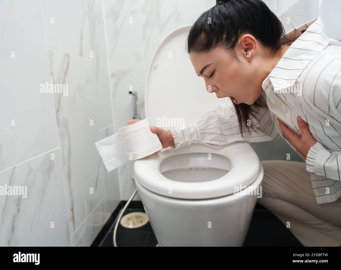 woman vomiting into toilet bowl in the bathroom Stock Photo - Alamy