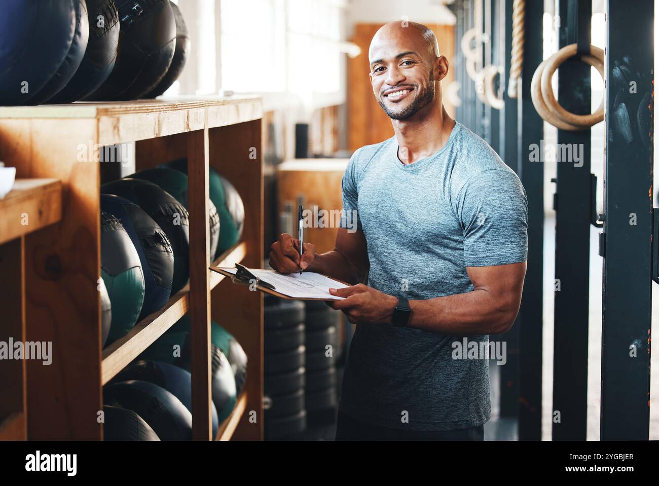 Portrait, clipboard and planning with man in gym for fitness instructor ...