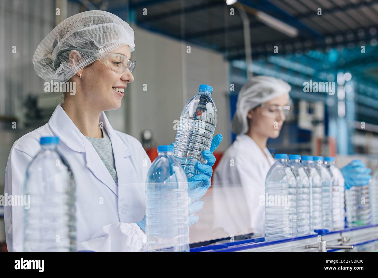 Women worker quality control in Drinking water factory. Production line ...