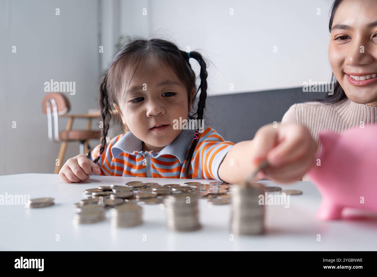 Mother Teaching Daughter Financial Literacy with Coins and Piggy Bank ...
