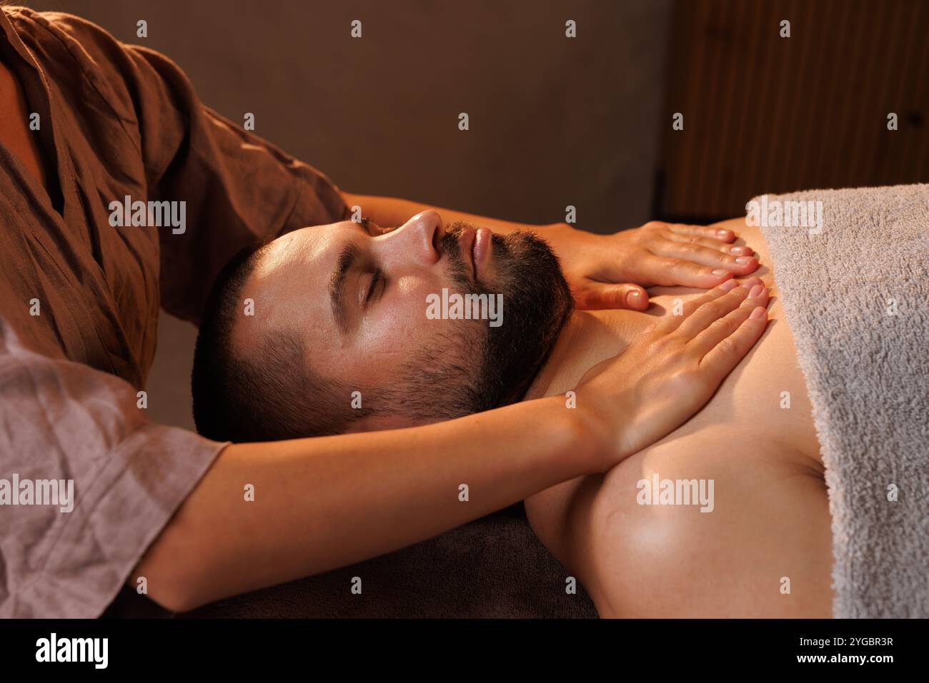Man relaxing during a chest massage at a spa with a serene expression. Wellness Hotel Concept ...