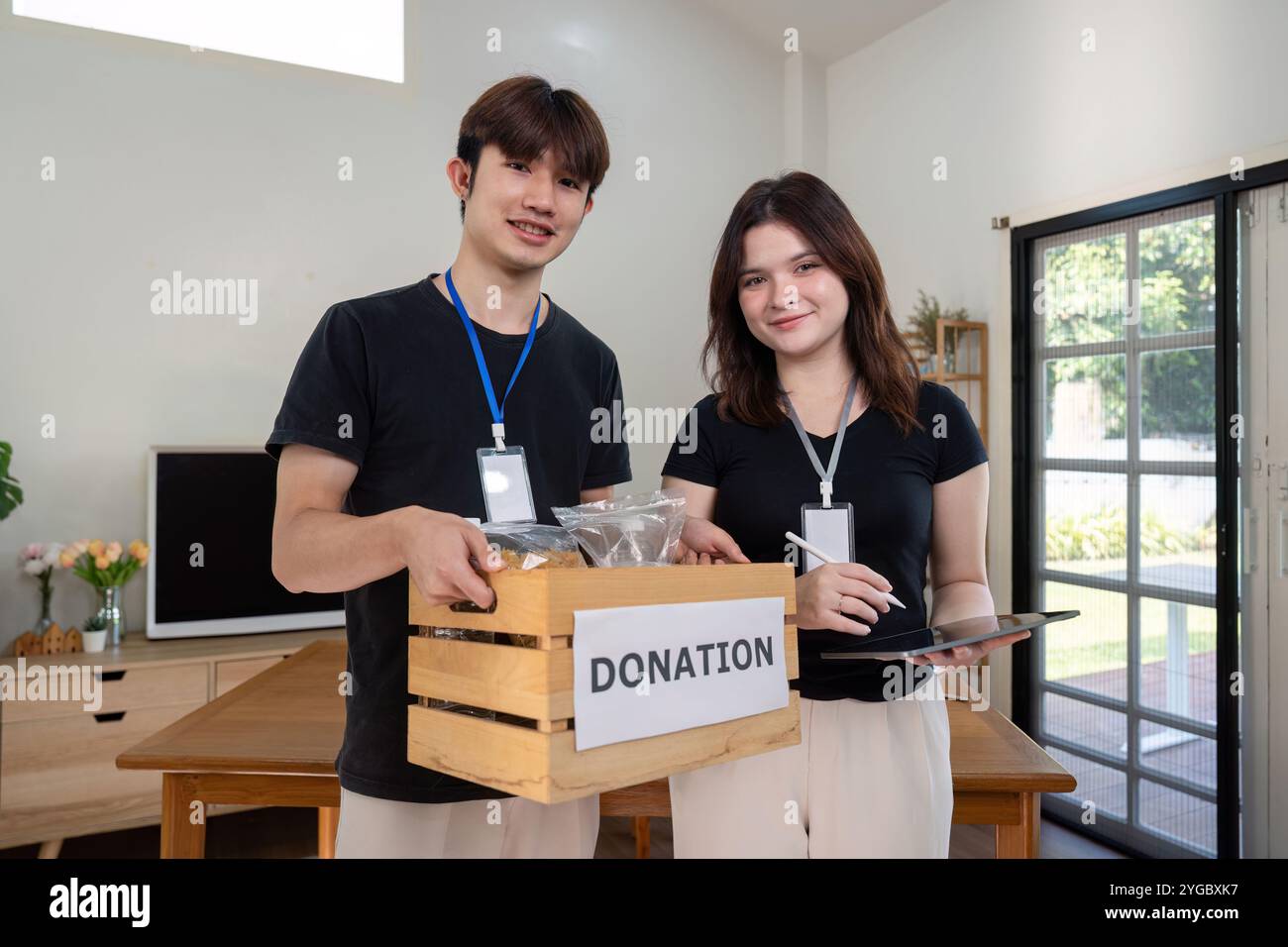 Smiling Volunteers Promoting Charitable Efforts with Donation Boxes ...
