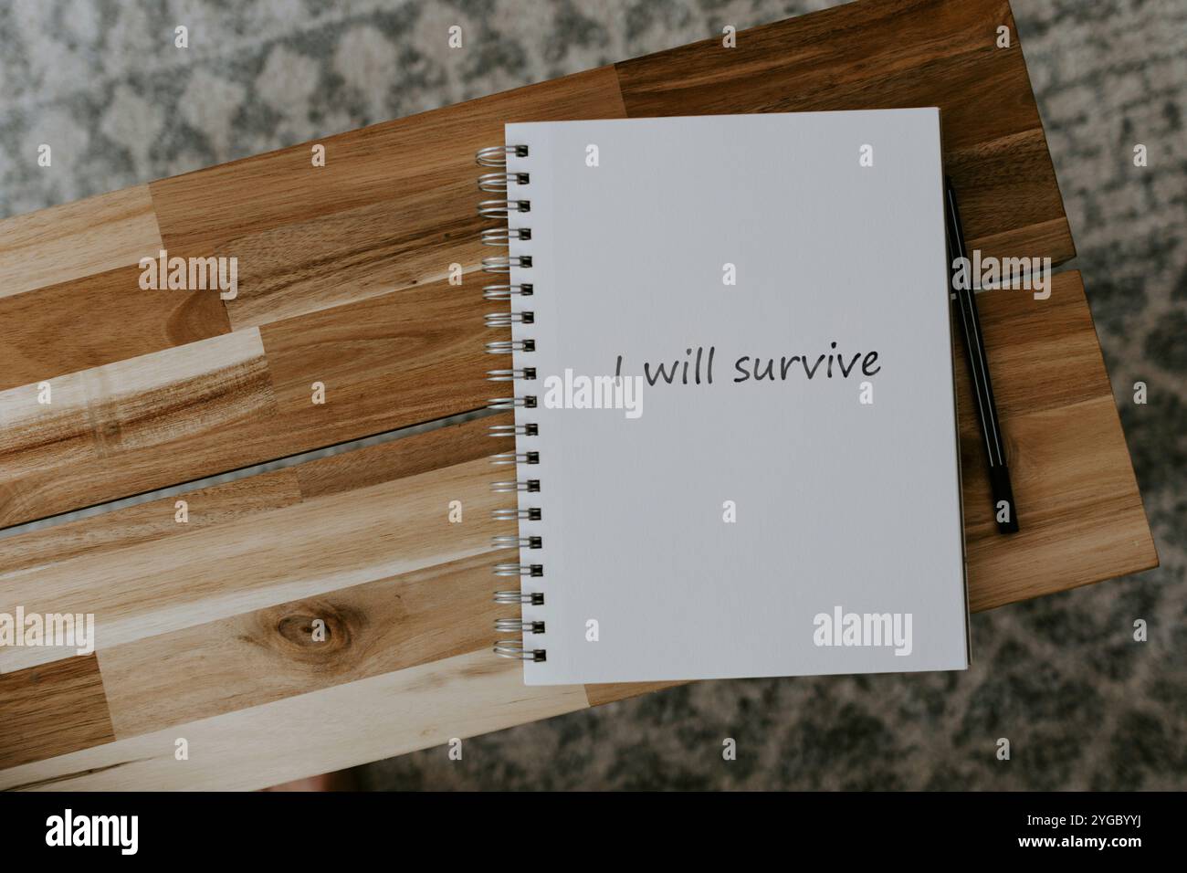 I will survive written on noted pad placed on coffee table alongside a ...