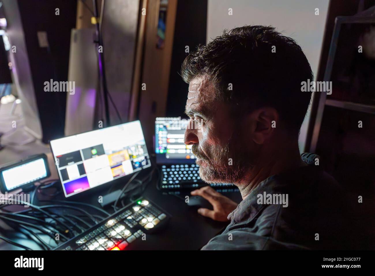 Cybersecurity Professional Analyzing Data on Multiple Screens in a Low-Light Workspace for ...