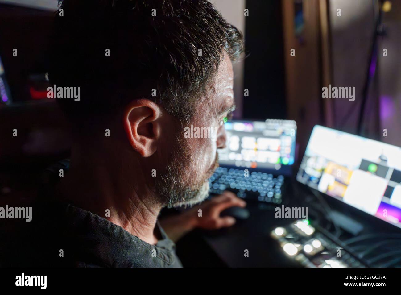 Cybersecurity Professional Analyzing Data on Multiple Screens in a Low-Light Workspace for ...