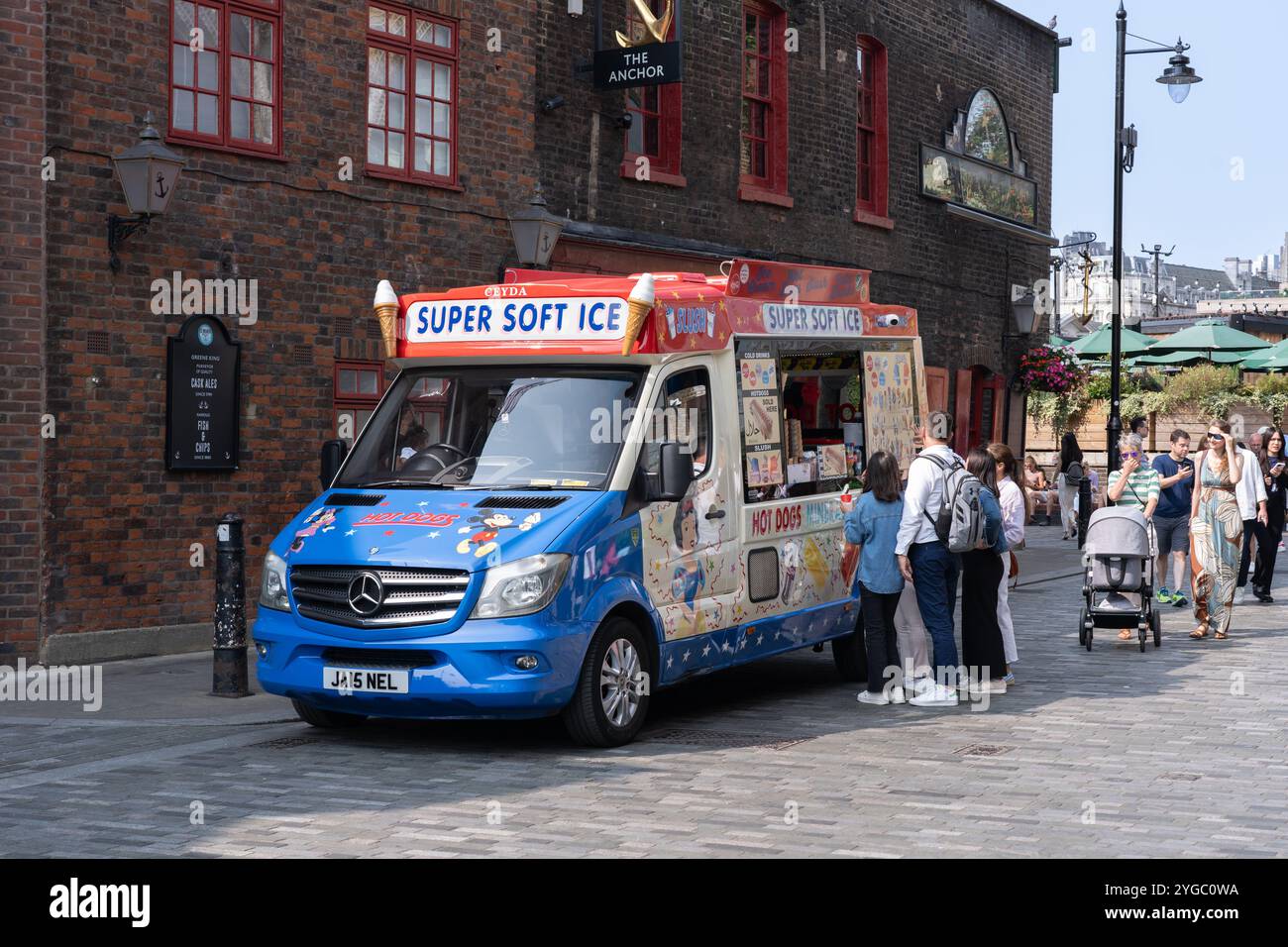 Customers queuing for ice cream at a Super Soft Ice ice cream van on a hot August day at Bank ...