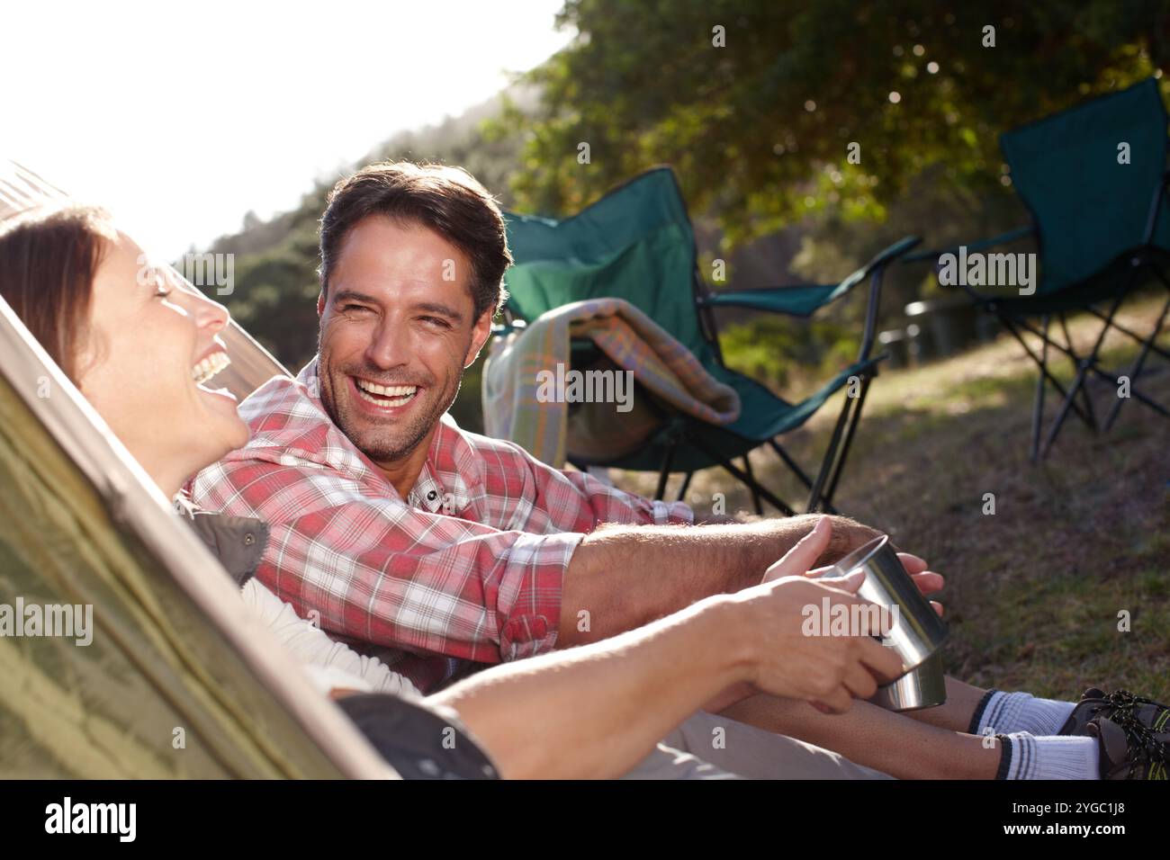 Couple, coffee and laughing in tent with camping for bonding, funny ...