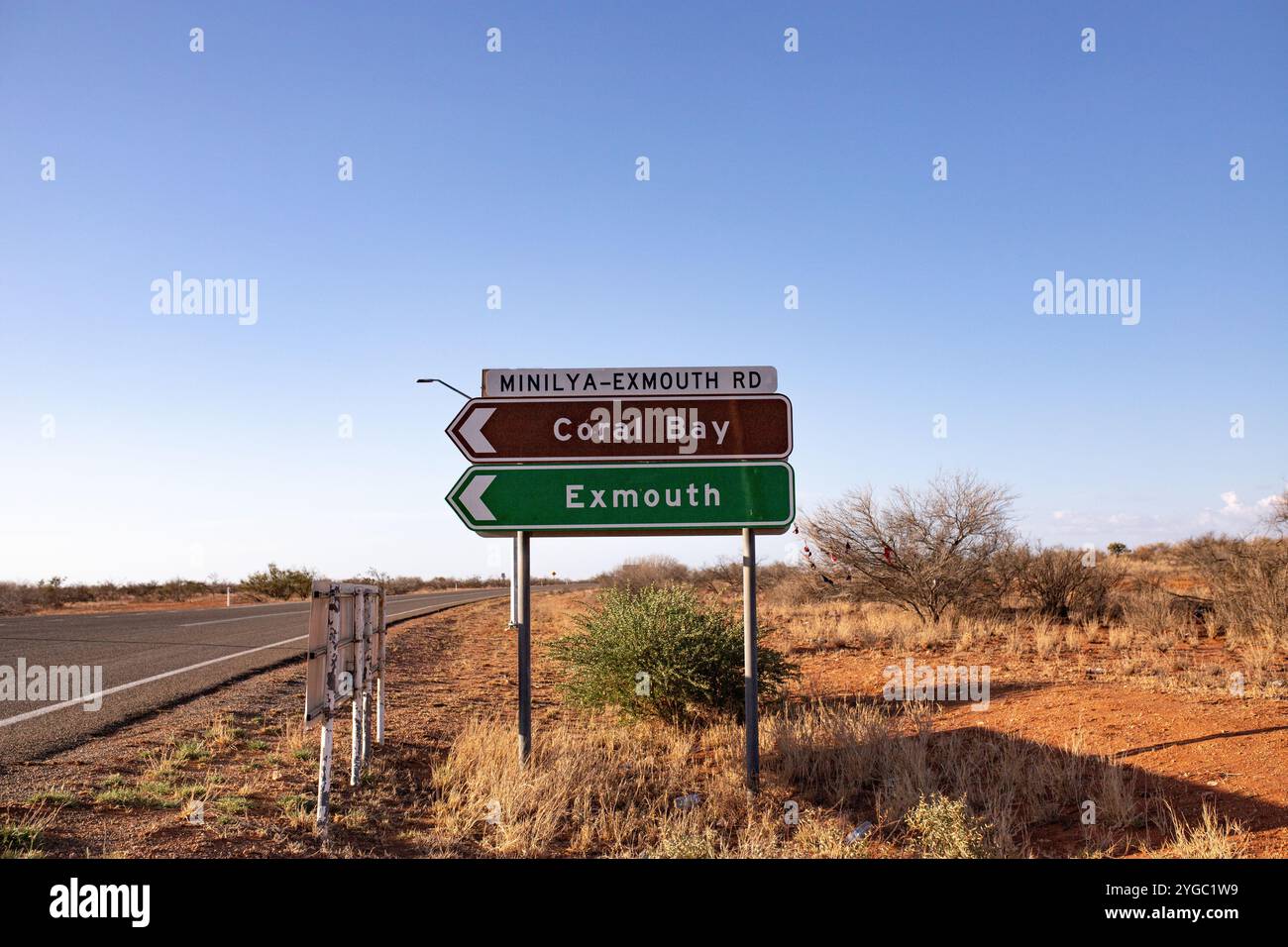 Brown and green directional destination road sign against a blue sky in ...