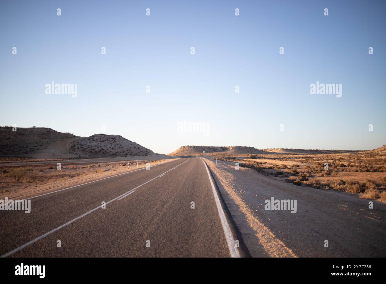 White painted road lines on an asphalt road. View from the side of the ...