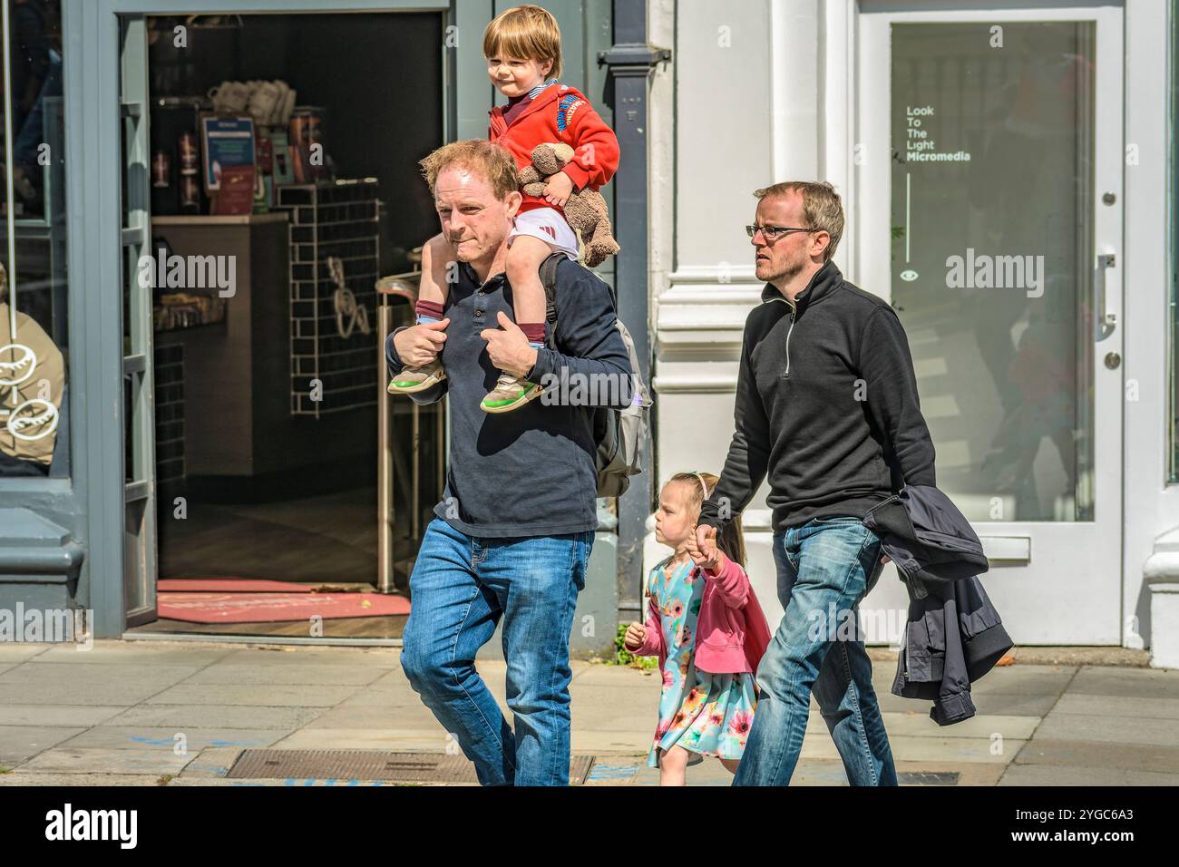 Two dads walking with their kids, spending time together outdoors Stock ...