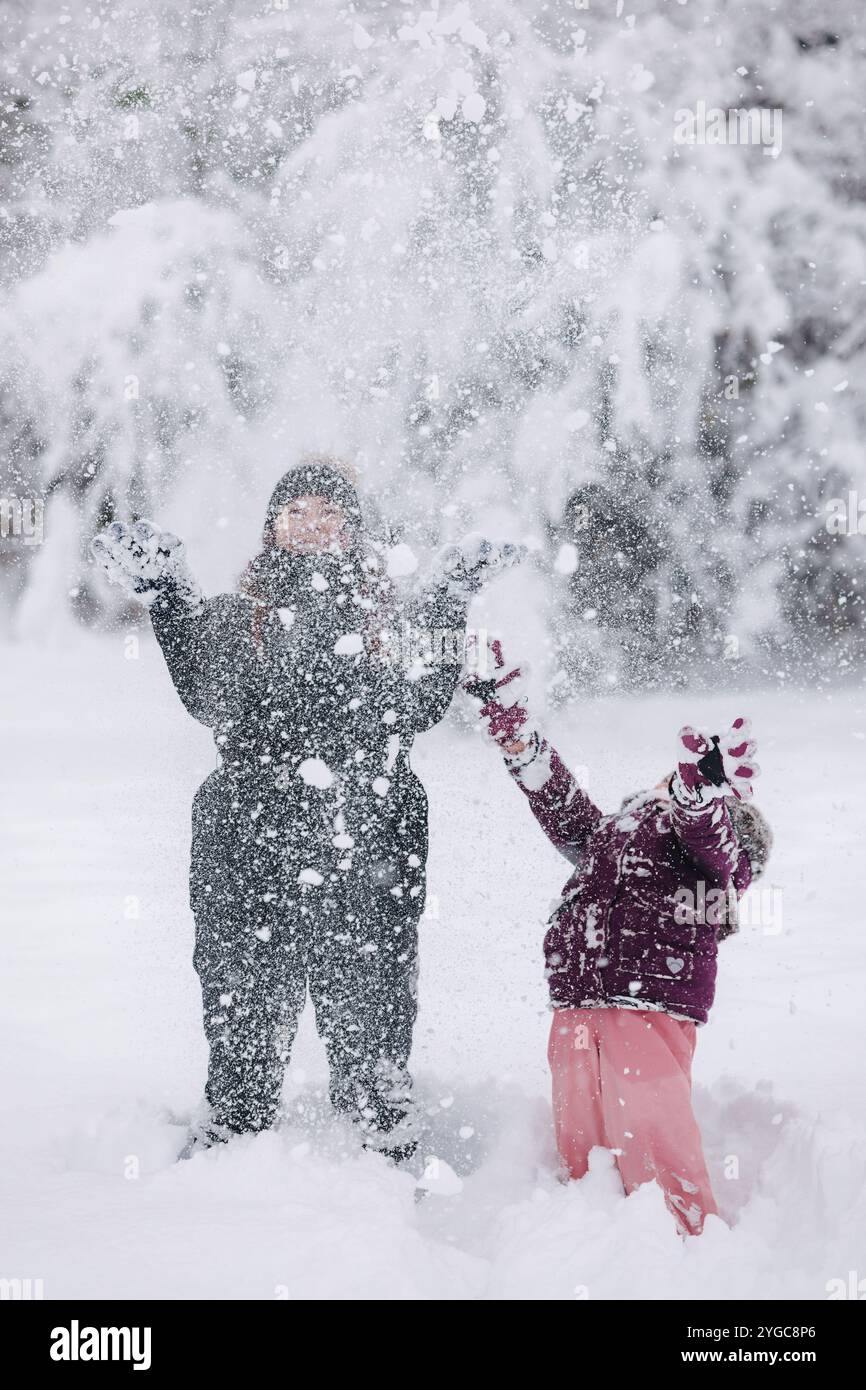 Heartwarming moment of a mother and daughter playing in the snow ...