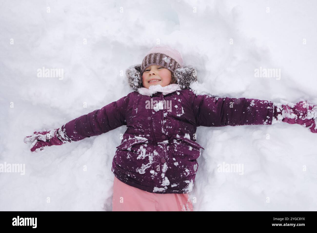 Little girl covered in snow, laughing and playing. A perfect scene of ...