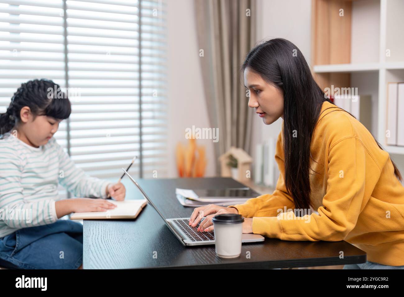 Studious Time Focused Mother and Daughter Engaged in Learning Stock Photo - Alamy