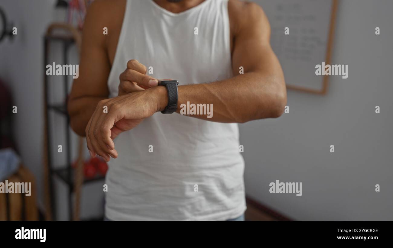Man wearing smart watch inside gym checking time during workout in the ...